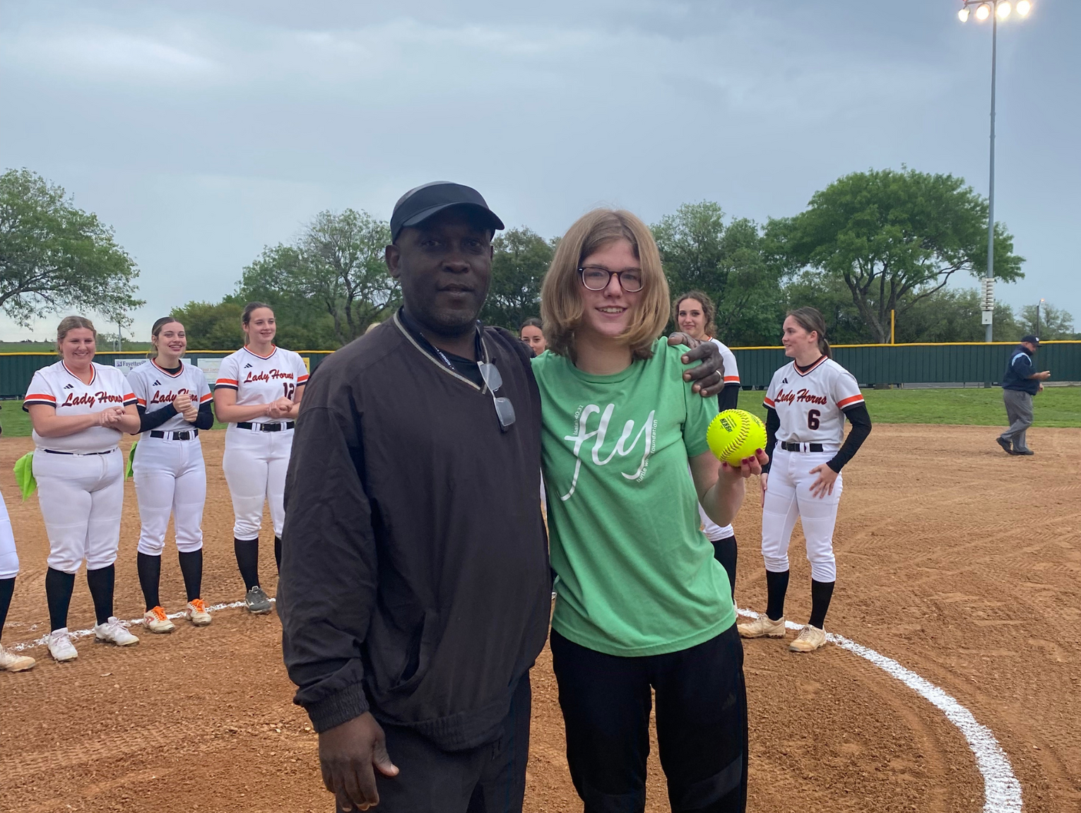 Softball team dedicates game, first pitch to Turtle Wing